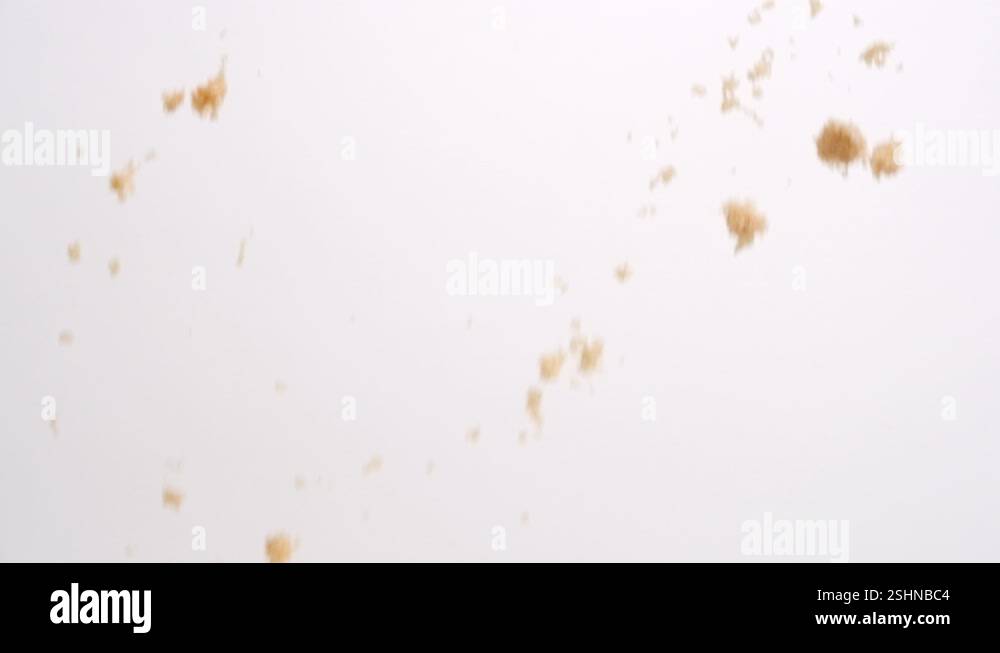 Brown sugar clumps falling in slow motion on white studio backdrop in ...