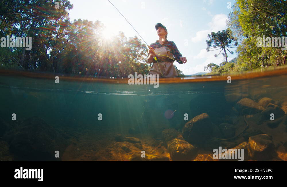 Angler in the river underwater view. Pretty woman angler wearing casual ...