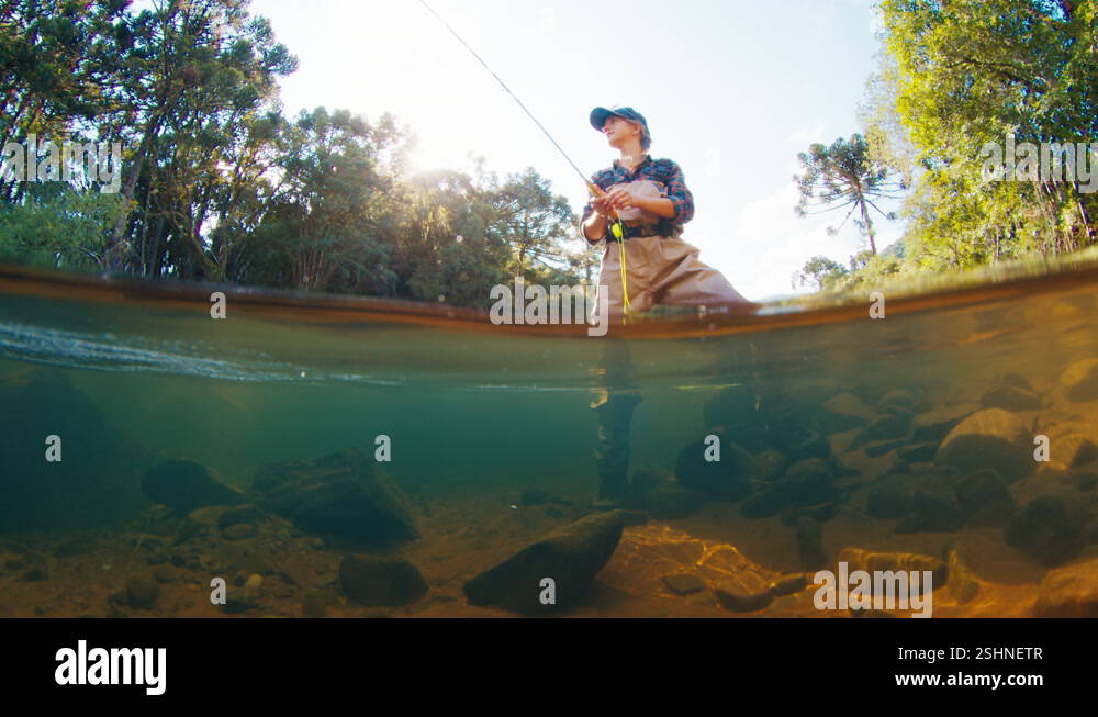 Angler in the river underwater view. Pretty woman angler wearing casual ...