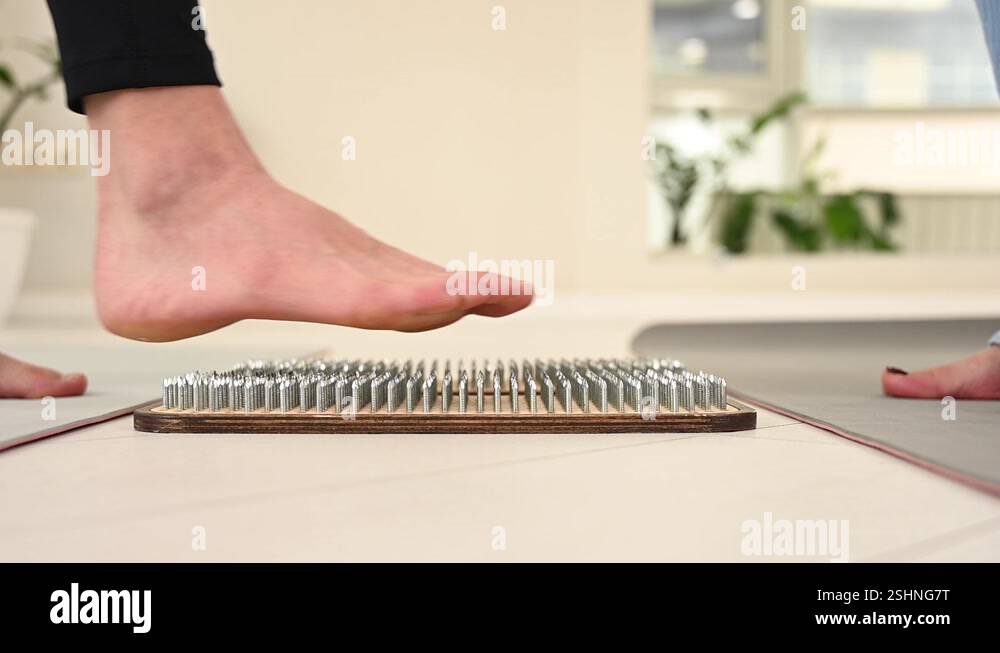 Caucasian woman stands on sadhu boards with therapist support Stock ...