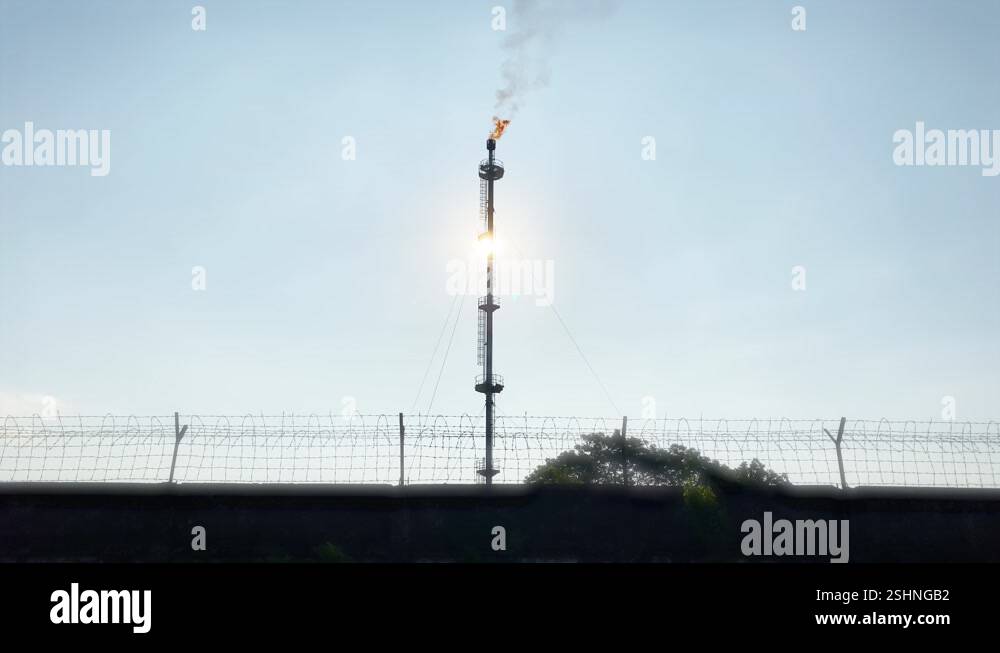 Flare pit gas combustion refinery behind wired fence, static, close up ...