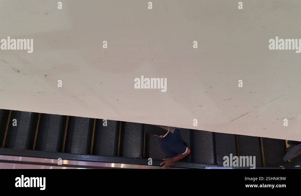 Simple escalator with glass railling and shiny metal moving up hide ...