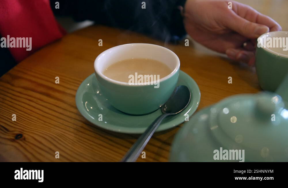 A woman pouring milk into tea cup Stock Video Footage - Alamy
