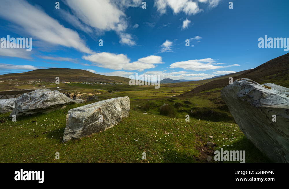 Timelapse of rocky grass landscape with moving clouds in the sky on ...
