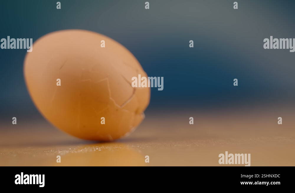 An egg falling on the table with cracks on the shell in Estonia Stock ...