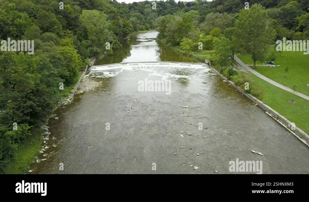 Drone flying up a river with a small waterfall in Toronto Stock Video ...