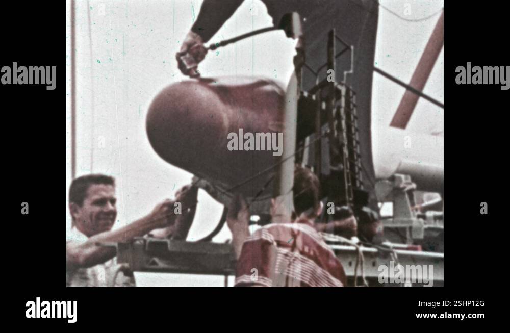 1950s: Three men surround a warhead, affix it to a rocket. Rocket ...