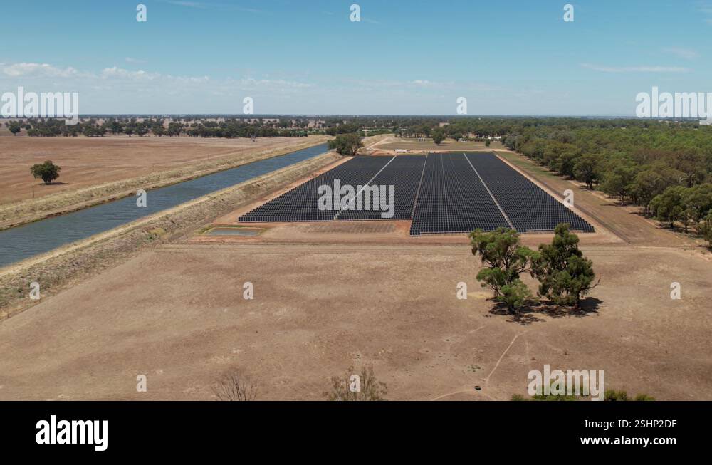 Aerial view of solar farm beside an irrigation canal on a traditional ...