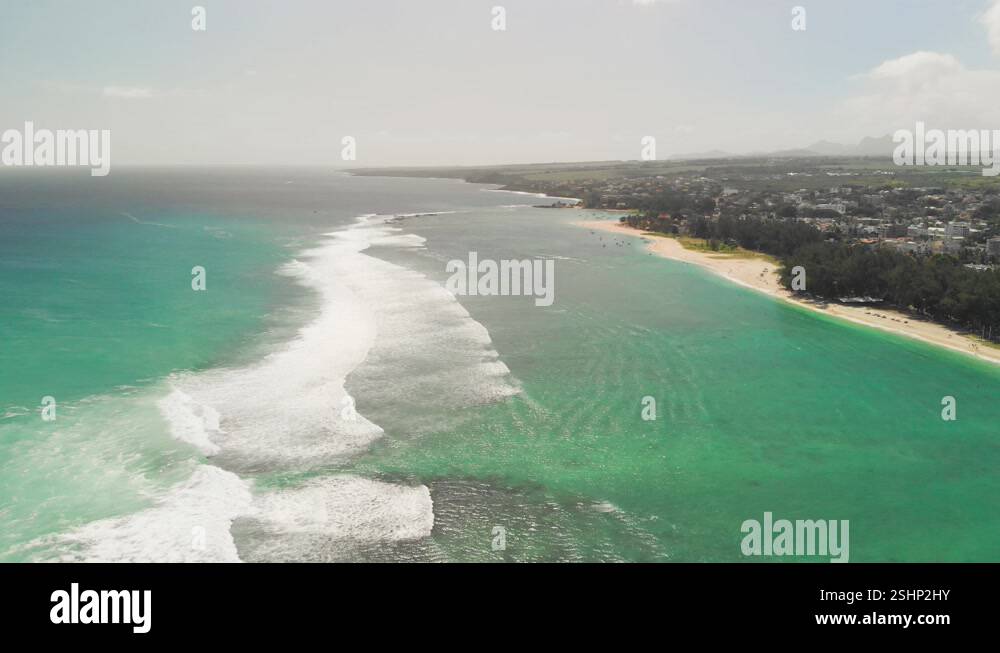 Waters of the Indian Ocean at a long beach of fine white sand dotted ...