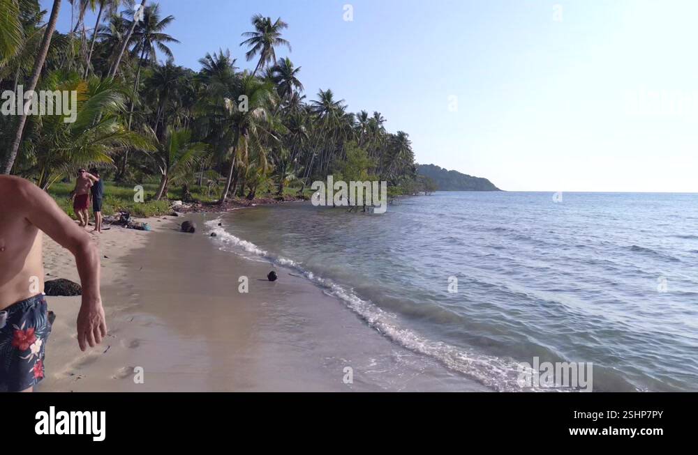 trash hero man pulls big heavy garbage bag over beach. Gorgeous aerial ...
