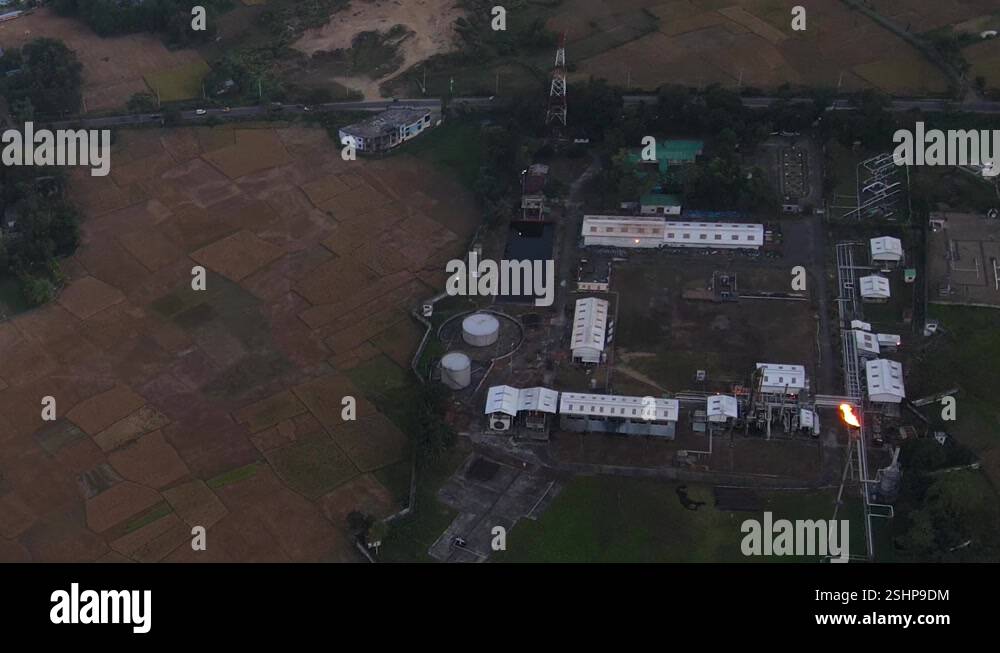 Aerial view of gas plant in the middle of rice paddy field on the bank ...
