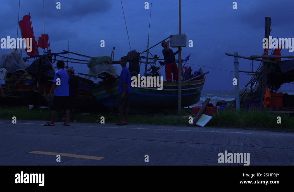 People caring for traditional wooden boats in dangerous windy weather ...