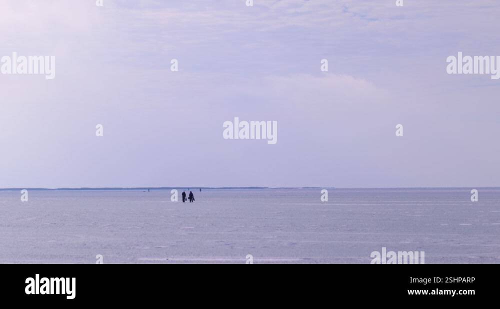 Two fisher men walking on frozen lake, winter, ice fishing, wide Stock ...
