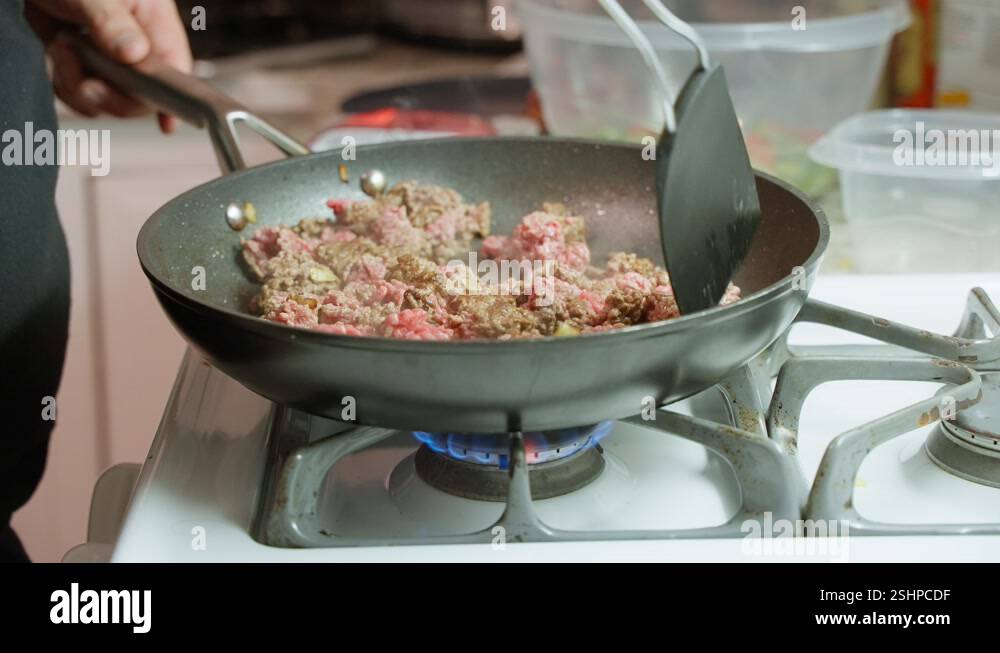 Mince beef browning and stirred with black spatula caucasian home chef ...