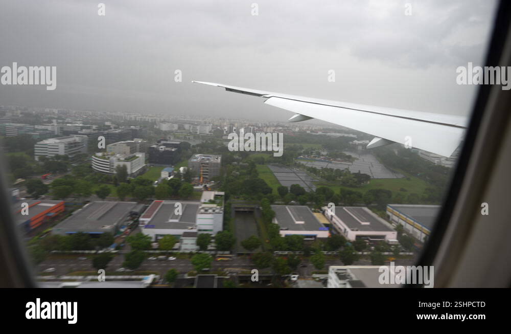 Approaching Singapore Airport at bad weather conditions from airplane ...