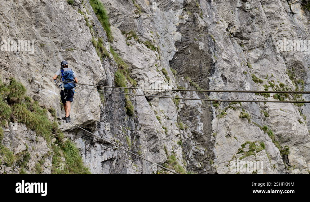 Man on Via Ferrata crossing monkey bridge Stock Video Footage - Alamy