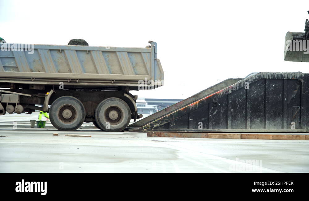 Dumping cement in a concrete paving machine Stock Video Footage - Alamy