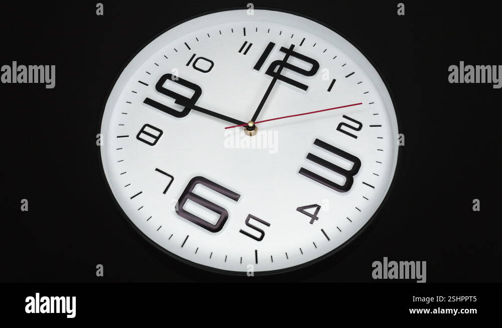 A White Wall Clock On Black Background With A Time Of 9.00 Am Or Pm. A ...