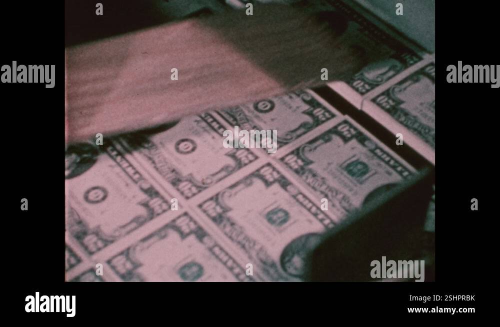 1970s: Man operates printing press. Worker at controls. Man picks up ...