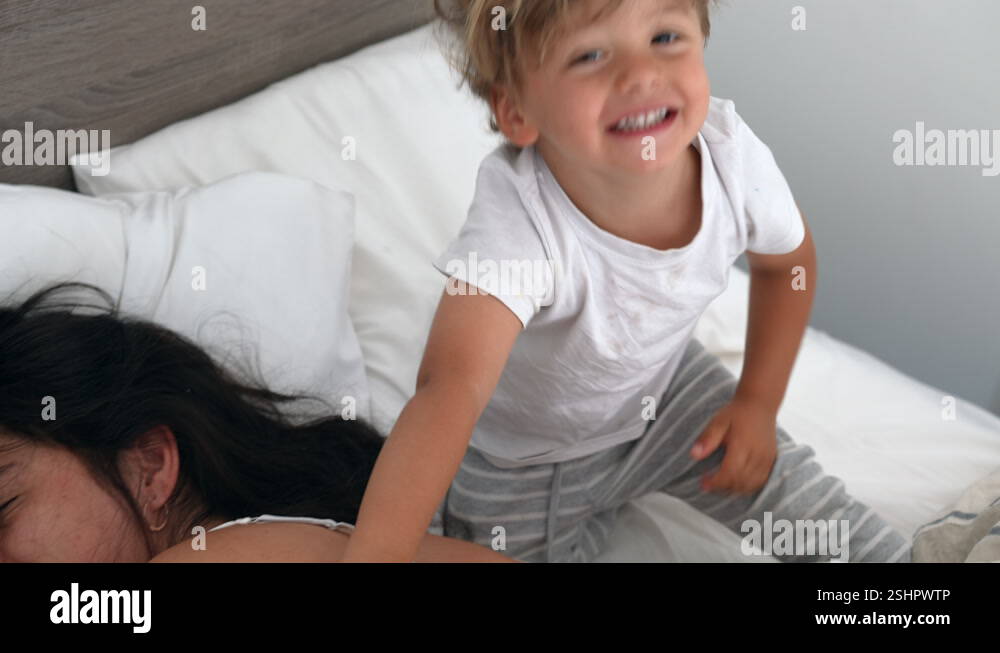 Little boy son trying to wake up mom in morning bed. Child waking up sleepi Stock Video Footage ...