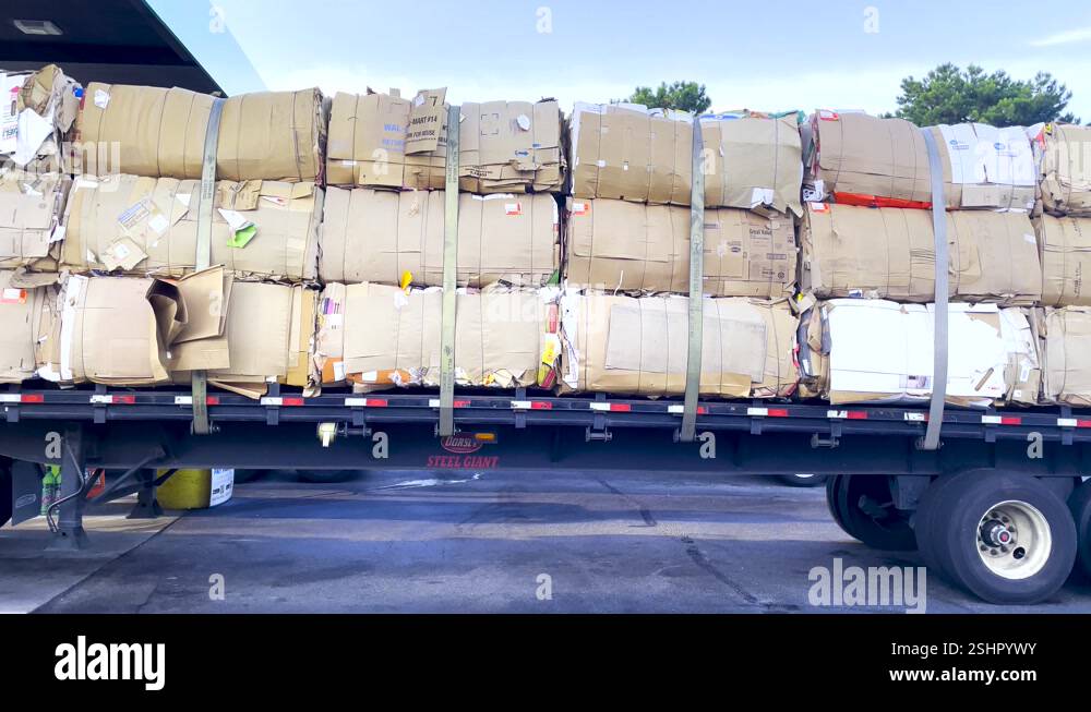 A semi truck with cardboard bales strapped down to the bed at a diesel ...