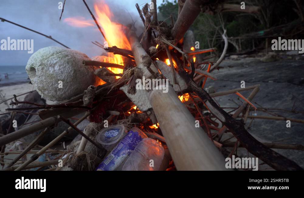 Fire on the beach with plastic parts and garbage. Blazing campfire on ...