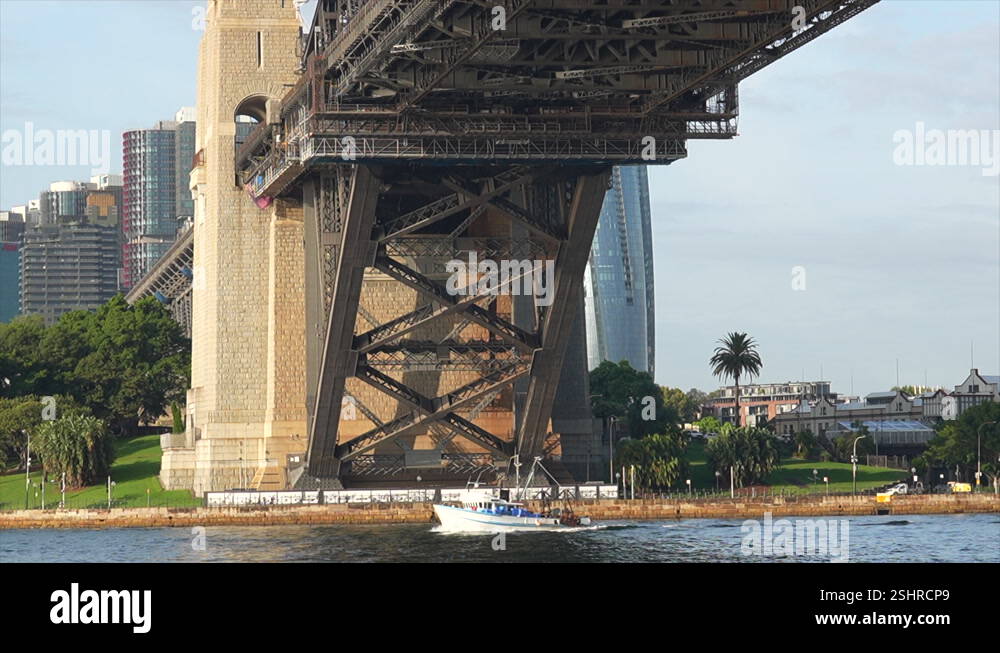 A fishing trawler boat passes underneath the Sydney Harbour Bridge ...
