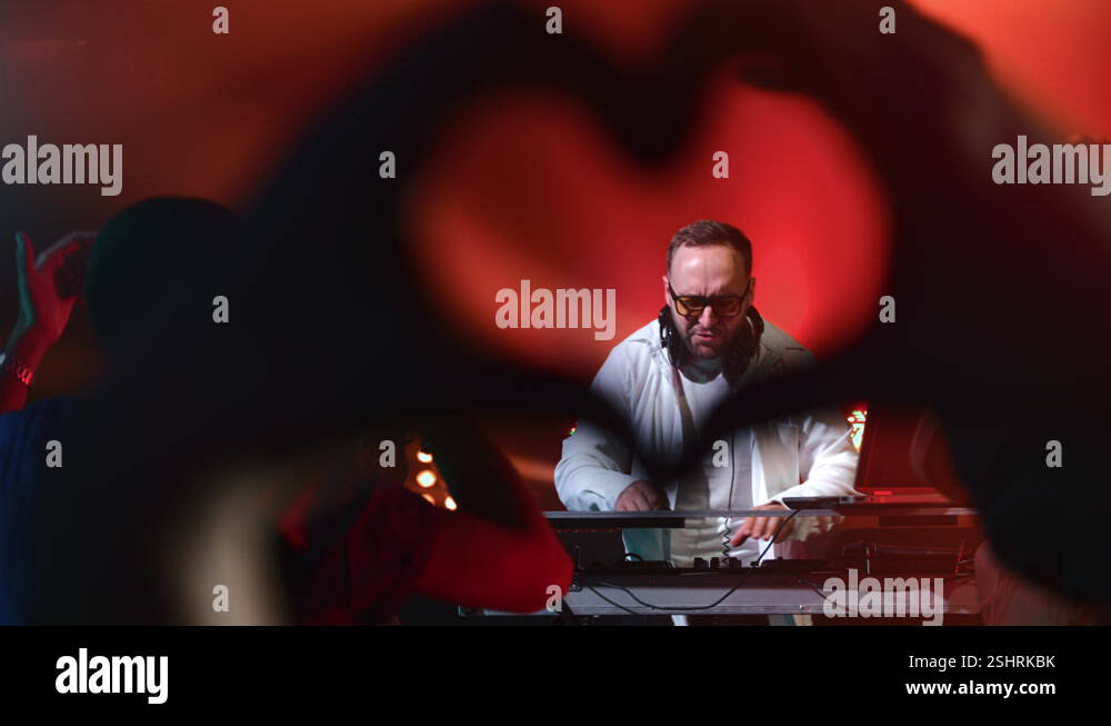 Charismatic man DJ mixing music dancing at nightclub disco party ...