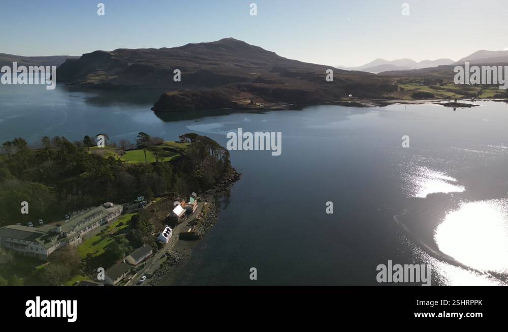 Pan across sparkling harbour towards The Lump at Portree Isle of Skye ...