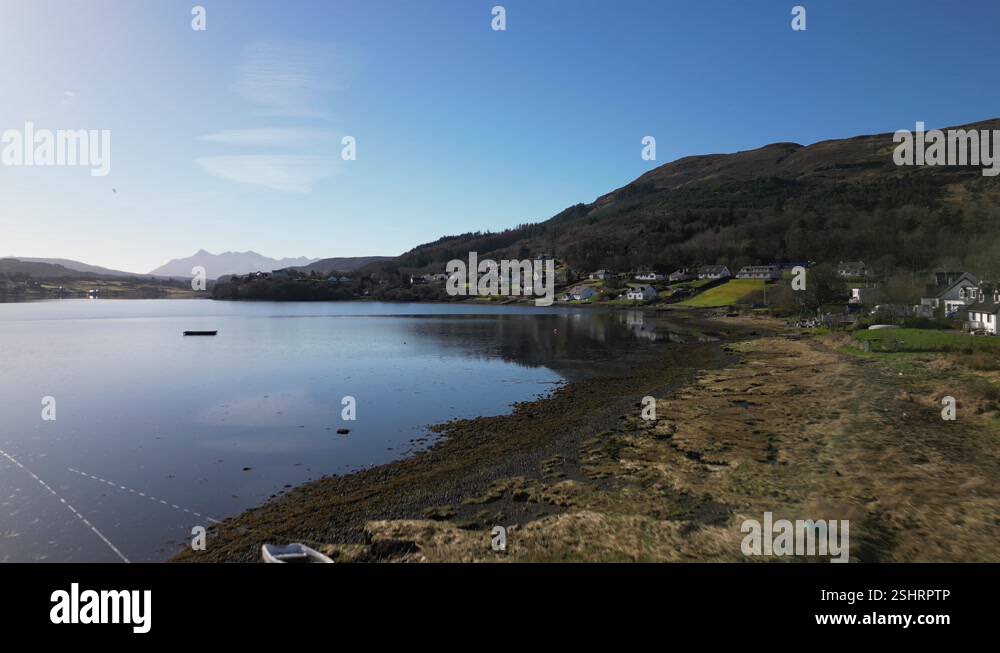 Flying over inlet and still water harbour of Portree Isle of Skye ...