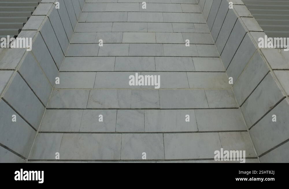 Tilt up a white facade of white stone high-rise house on a clear blue ...