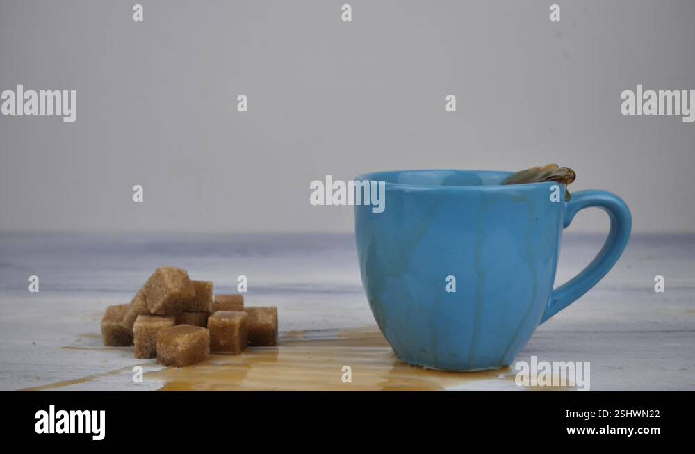 A cube of brown sugar falls into a cup with black tea Stock Video ...