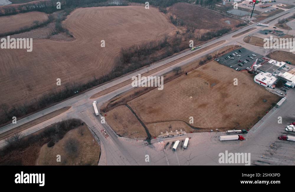 White semi truck and trailer enters on road making a right turn. Aerial ...