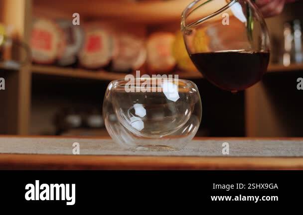 In a cozy setting, a person pours coffee and tea, creating an inviting ...