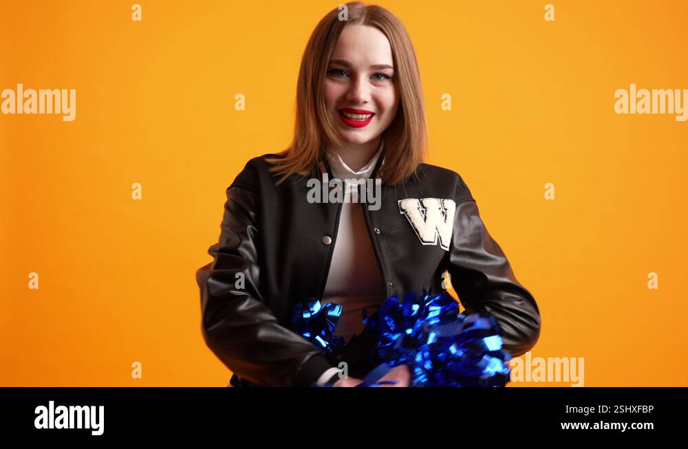 pretty and cheerful Caucasian cheerleader holding blue pom-poms, medium ...