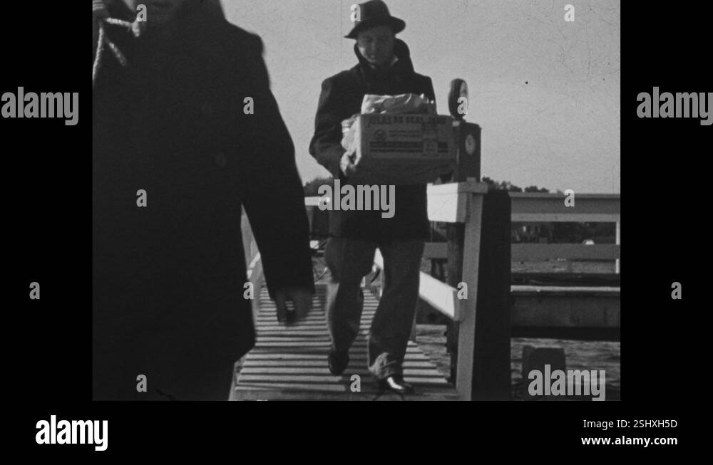 1940s: Various men and sailors walking down the dock carrying bags and ...
