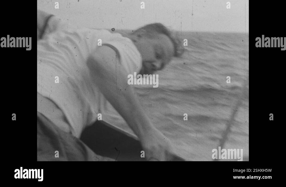 1940s: Man leaning over the side of the boat bouncing on the waves. Men ...