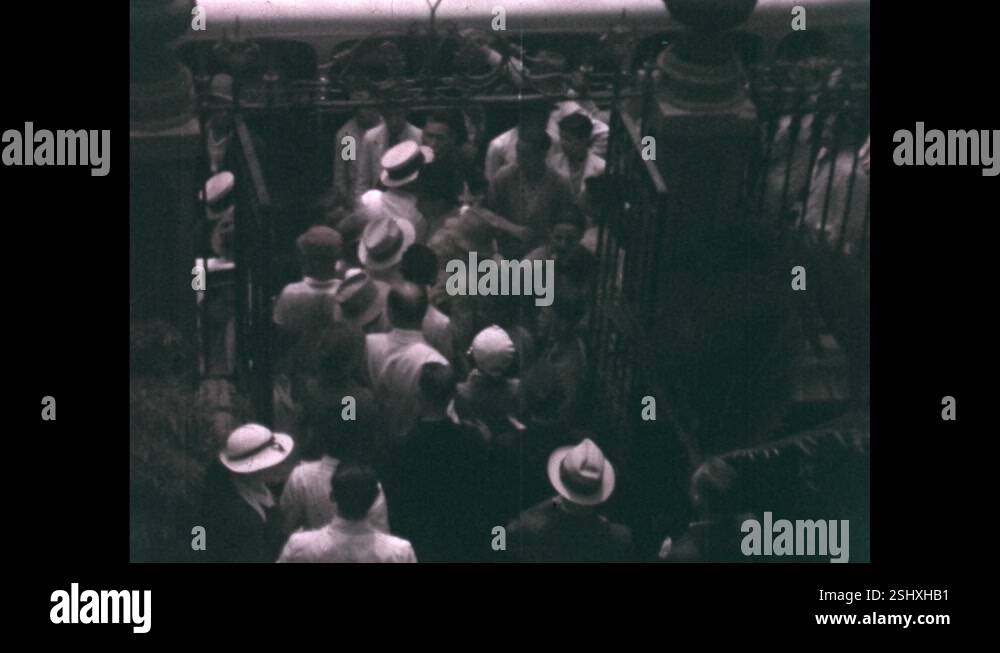 1930s: Crowd gathered around buses. High angle shots, crowd in city ...