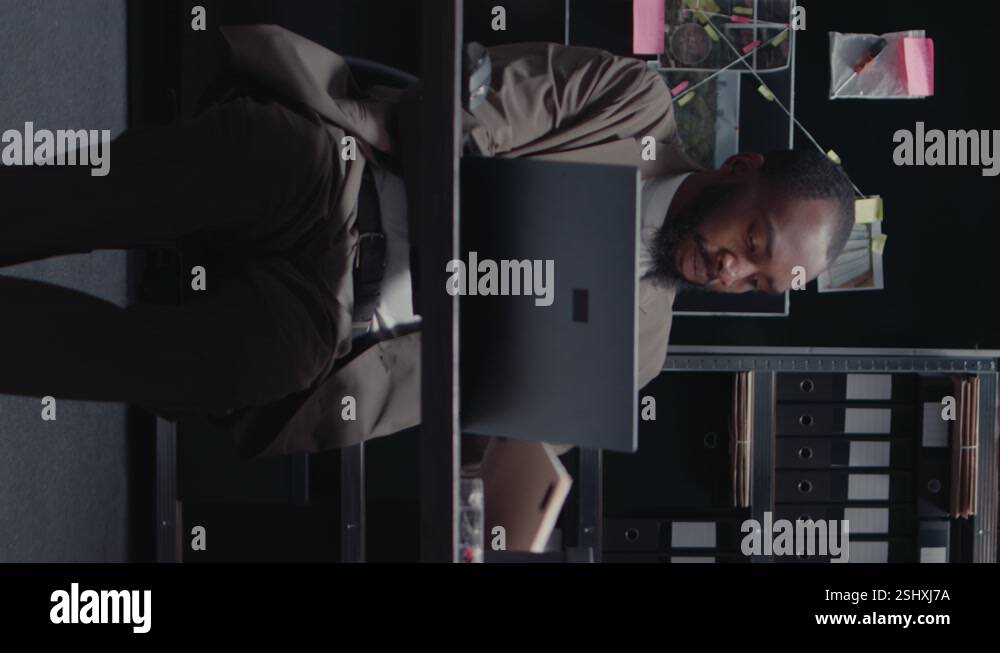 Vertical video: Male agent working with case information in evidence ...