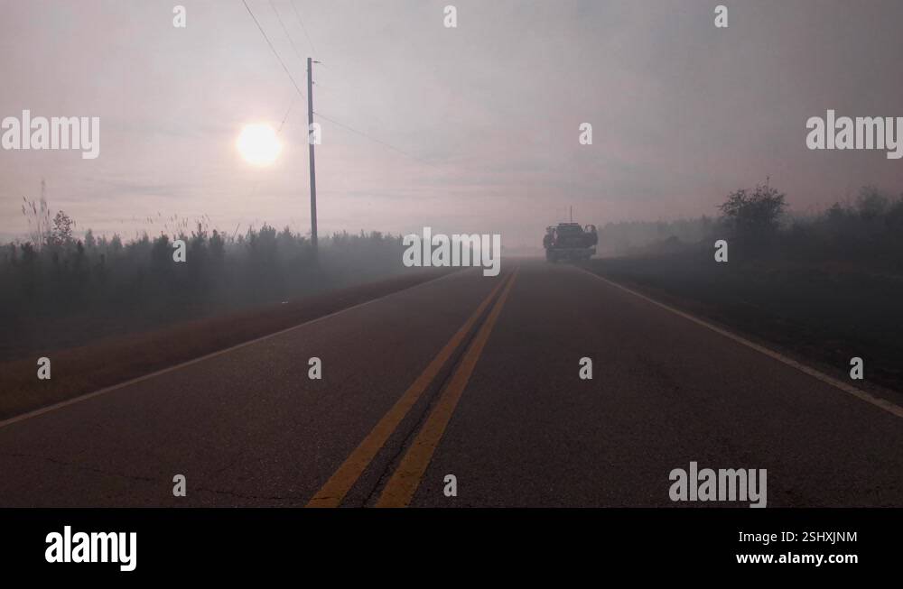 POV Driving through smoke from a forest fire passing a vintage fire ...
