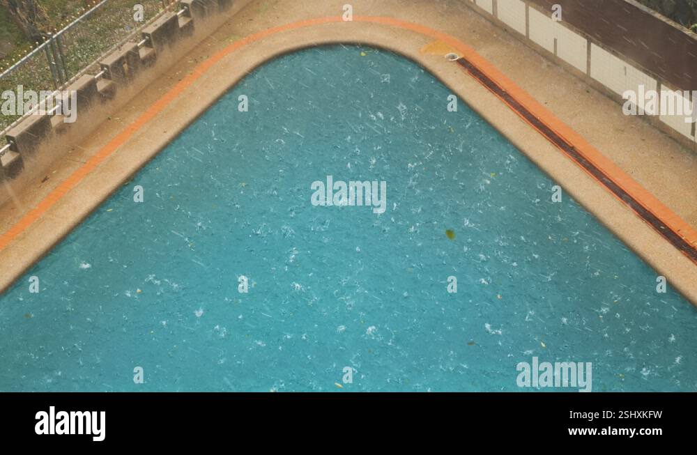 Swimming pool during heavy tropical rain with large hail, strong ...