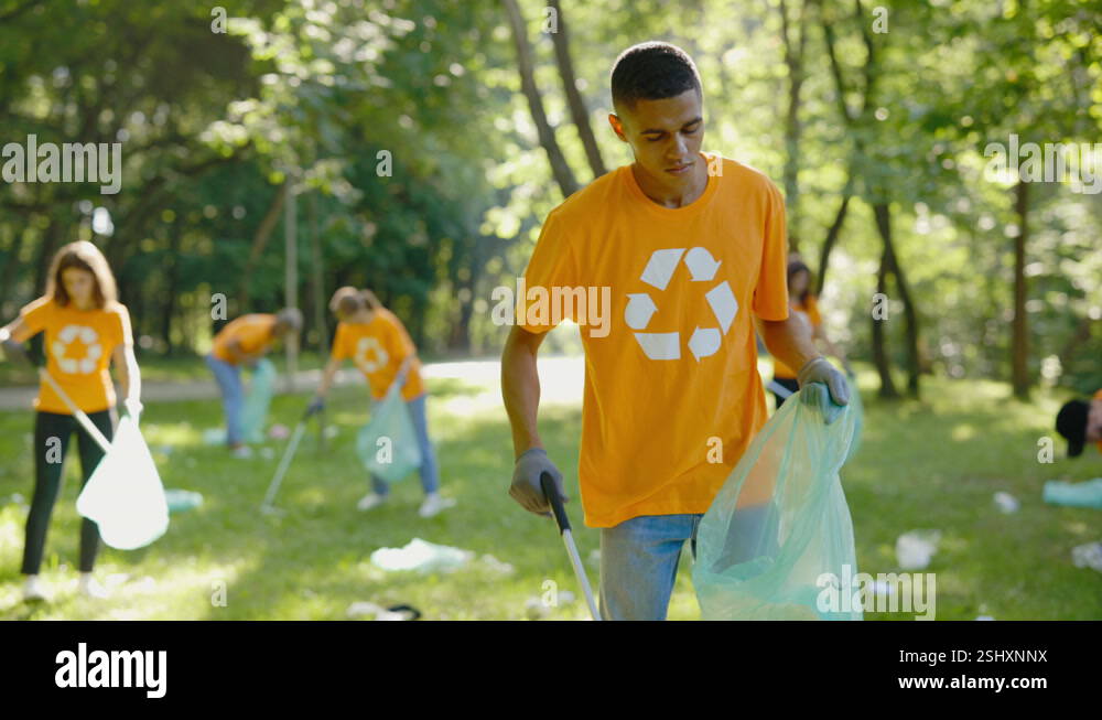 Multiethnic Young Man Using Trash Picker While Collecting Garbage in ...