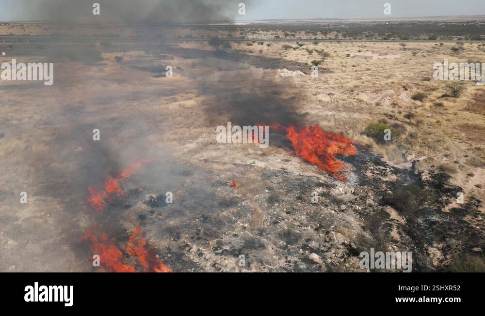 Aerial view around a rural fire, dry hay and bushes burning on an open ...