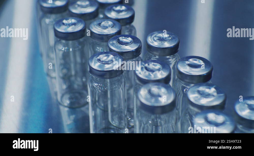 a lot of glass vials are moving along the production line.close-up ...