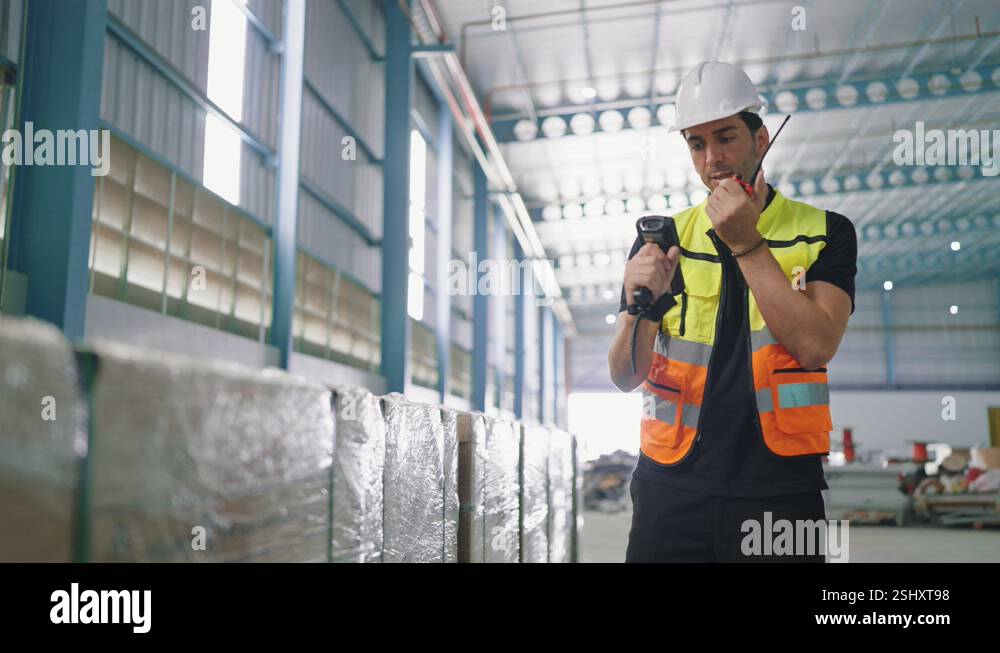 Engineer man holding barcode scanner, radio communication talking with ...