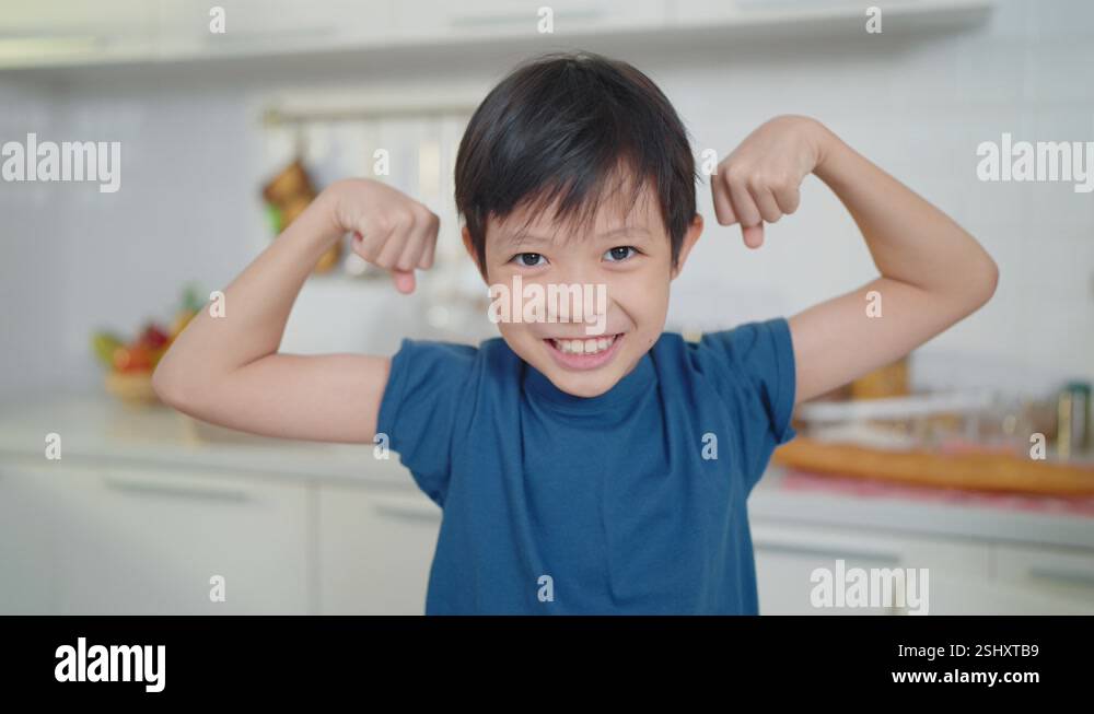 Asian little cute kid boy showing arm muscles. Raised hands and shows ...