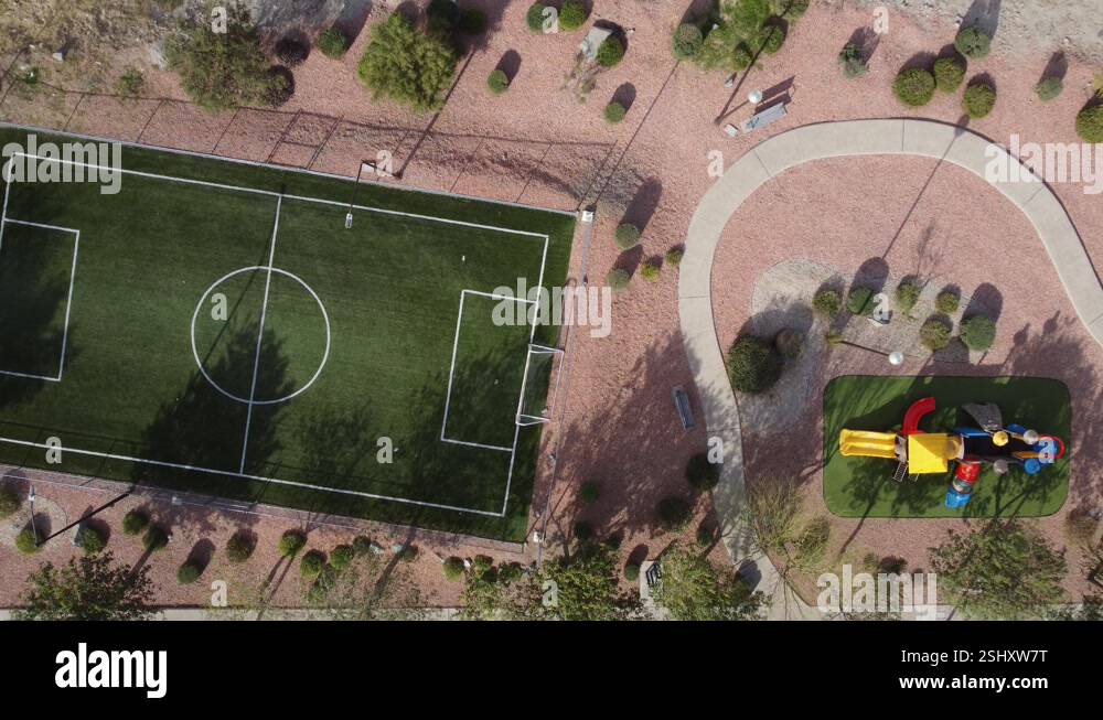 Top-down shot of a football pitch and a children's play park and trail ...