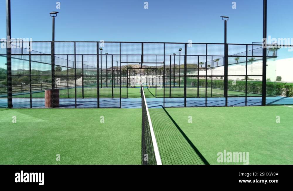 revealing dolly shot along a padel court net with stunning new courts ...
