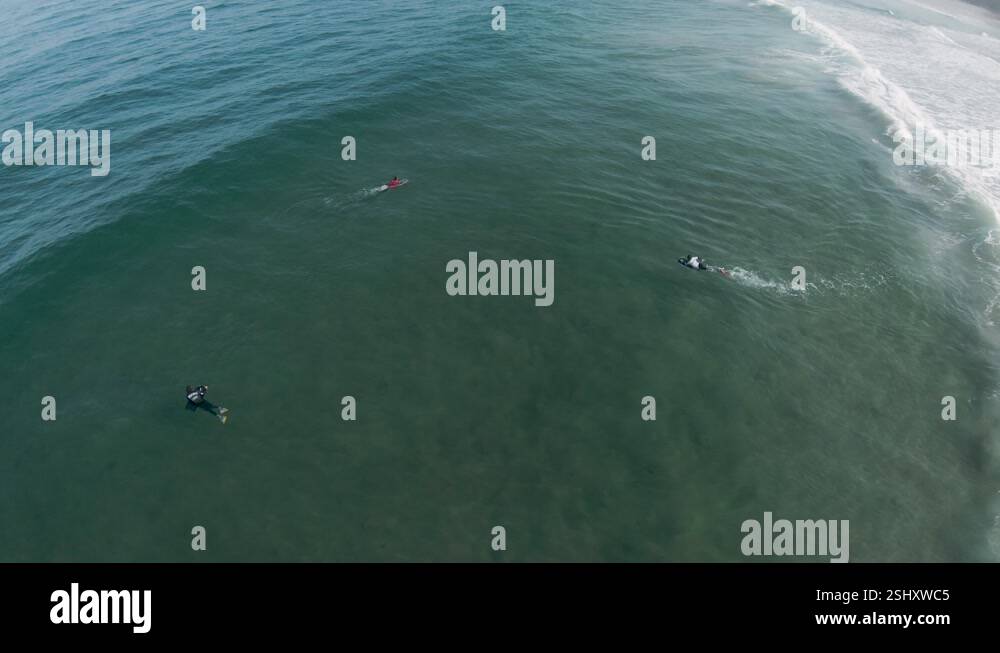 Gentle sweeping overview of ocean waves and bodyboarders swimming out ...