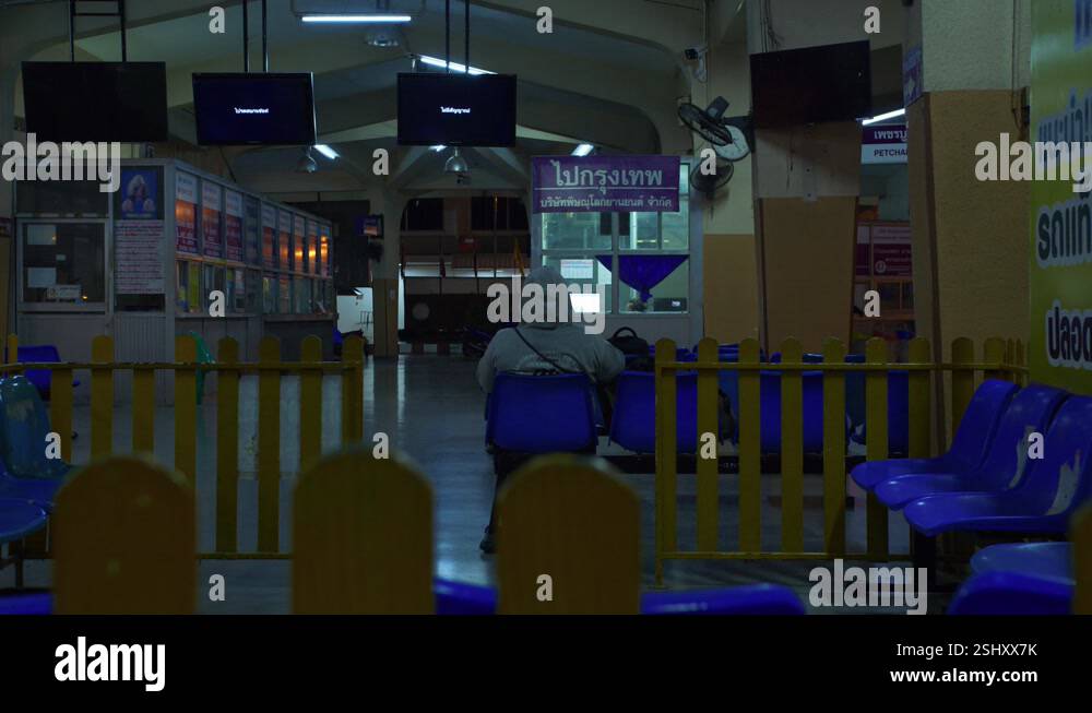 Empty bus station terminal at night with only one person waiting for ...